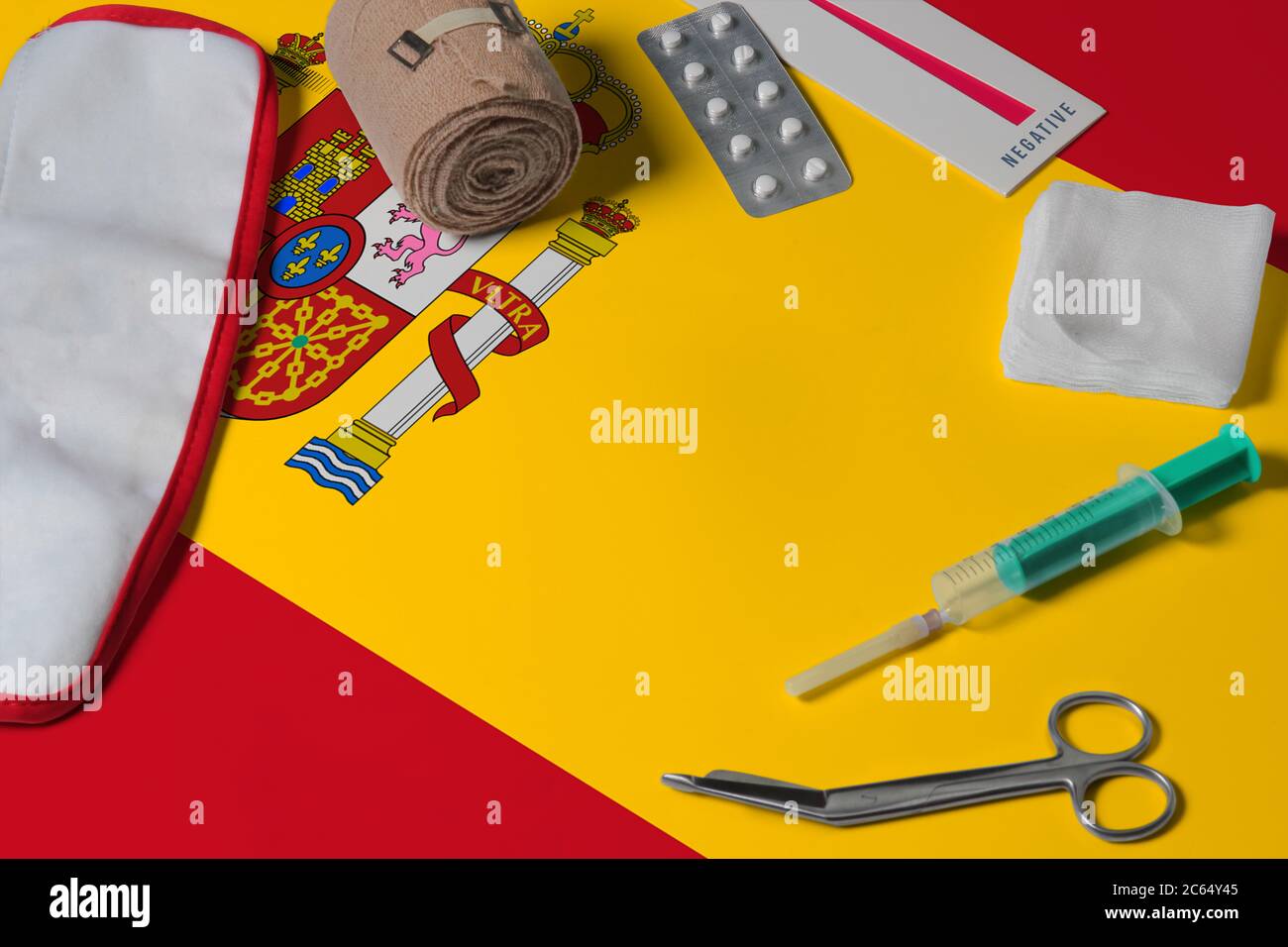 Spain flag with first aid medical kit on wooden table background ...