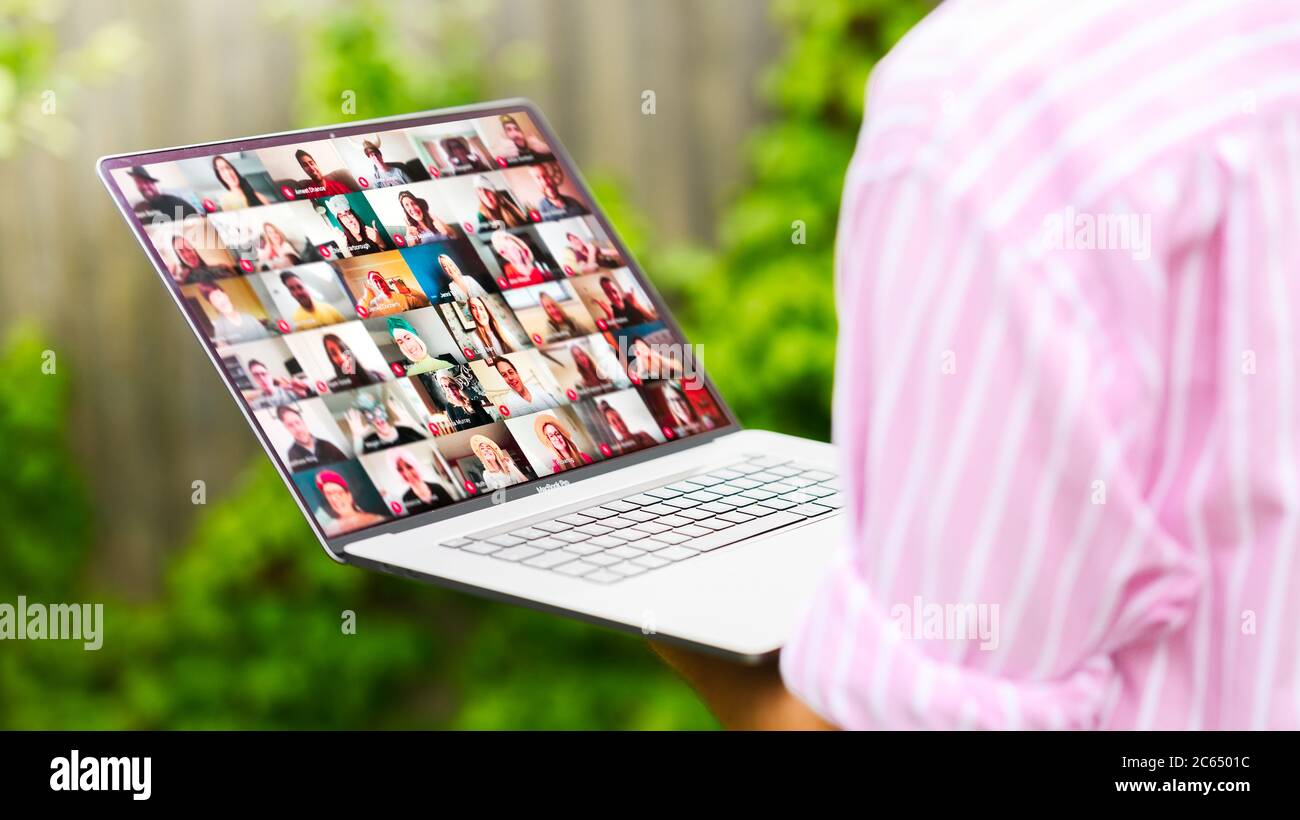 A Zoom video conference call being taken outdoors in a garden. The ...