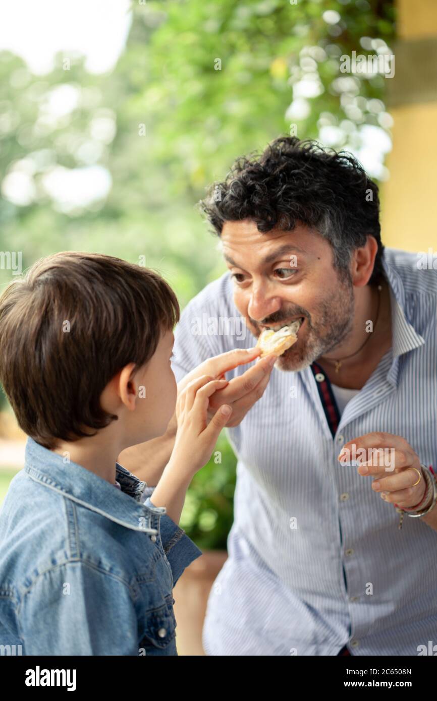 Boy and father eating bread Stock Photo - Alamy