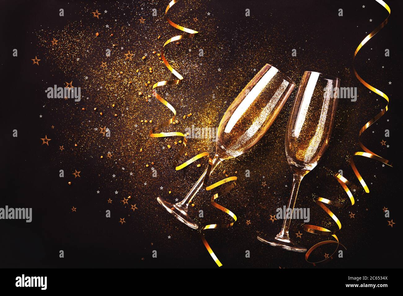 Celebration toast with champagne. Two champagne flutes with golden ...
