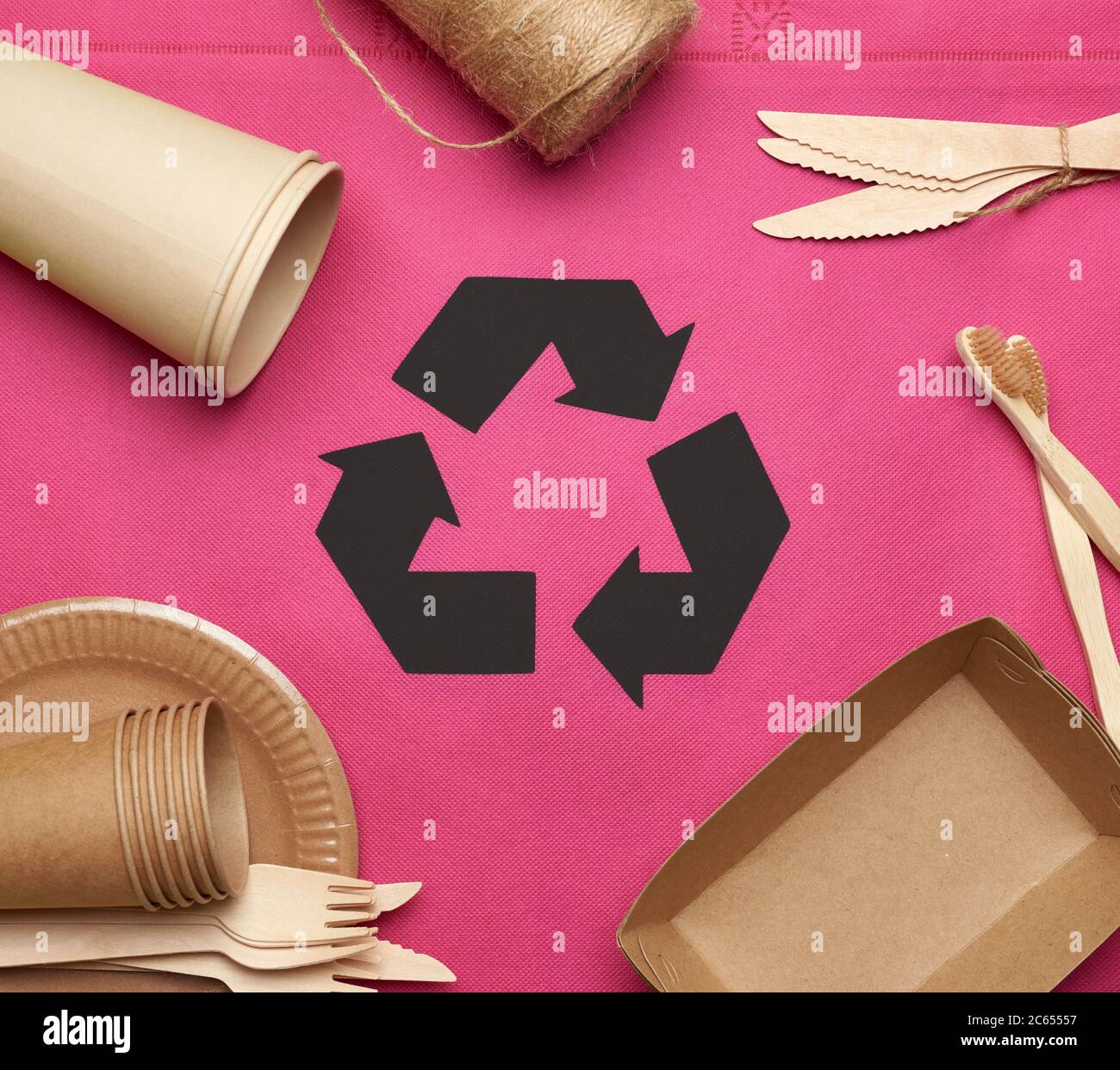 disposable tableware from brown craft paper on a pink background. View ...