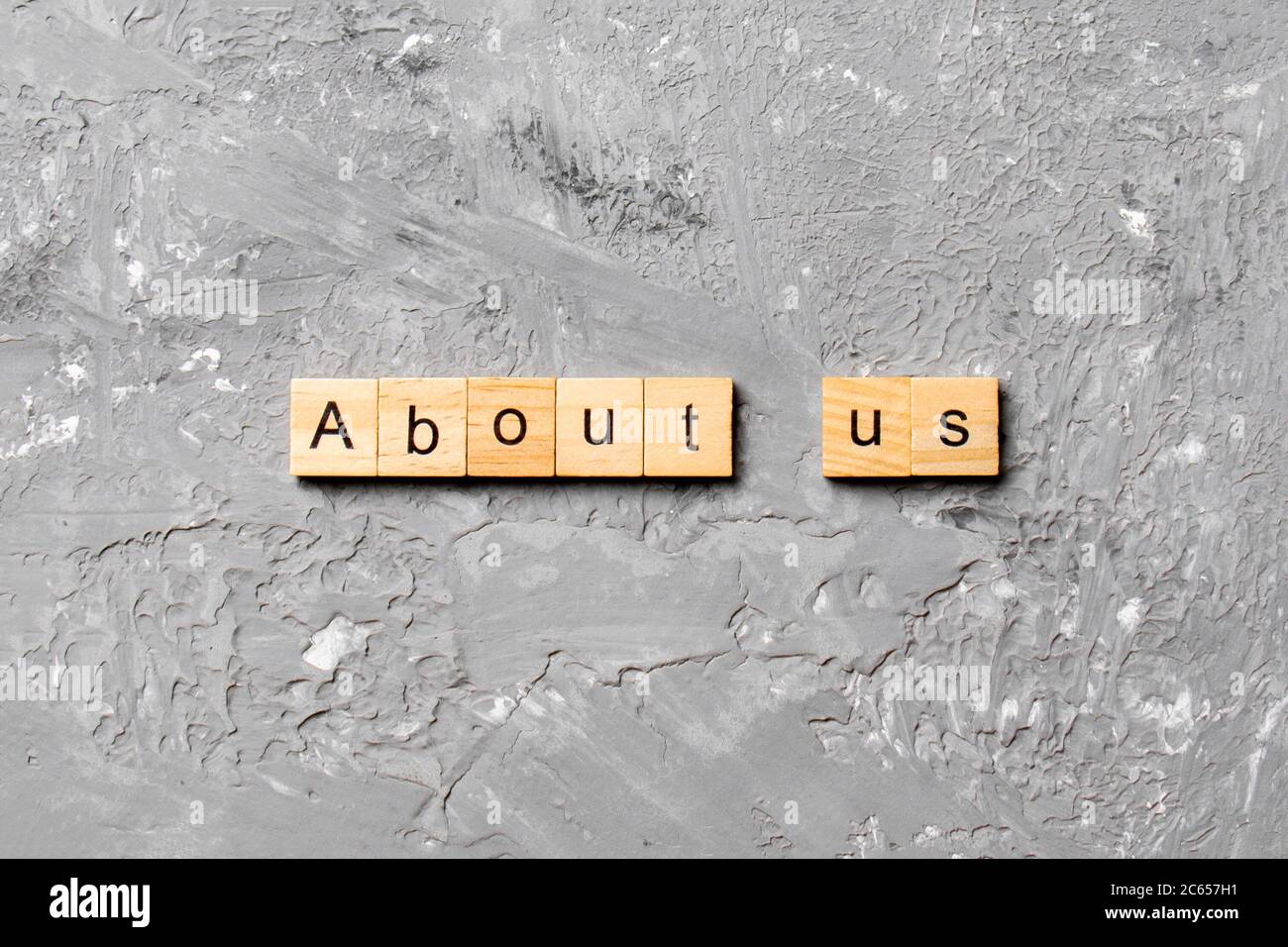 About us word written on wood block. About us text on cement table for ...