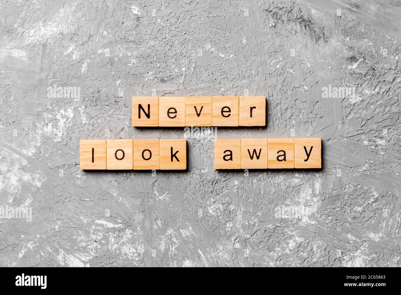 Never look away word written on wood block. Never look away text on ...