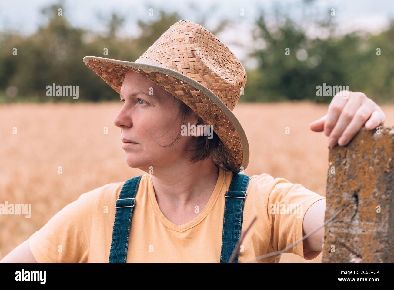 Female farmer posing in ripe barley field just before the harvest ...