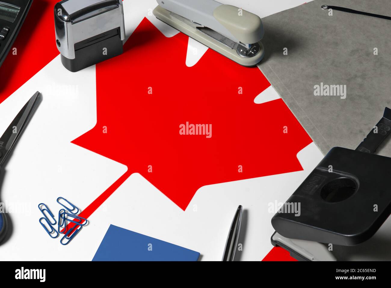 Canada flag with office clerk workplace background. National stationary ...