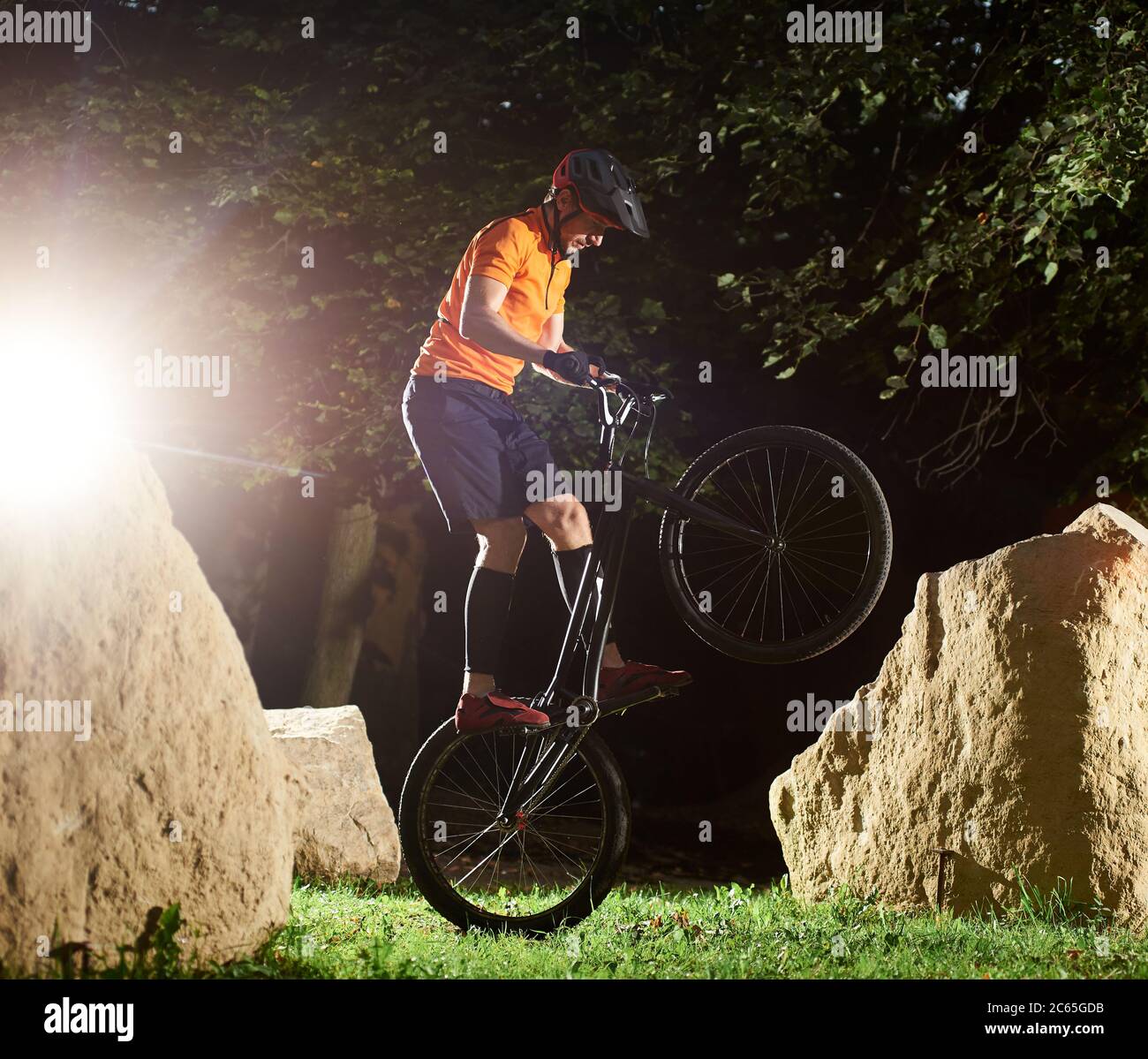 Extreme cyclist on bmx bike in park performing stunt keeping balance on ...