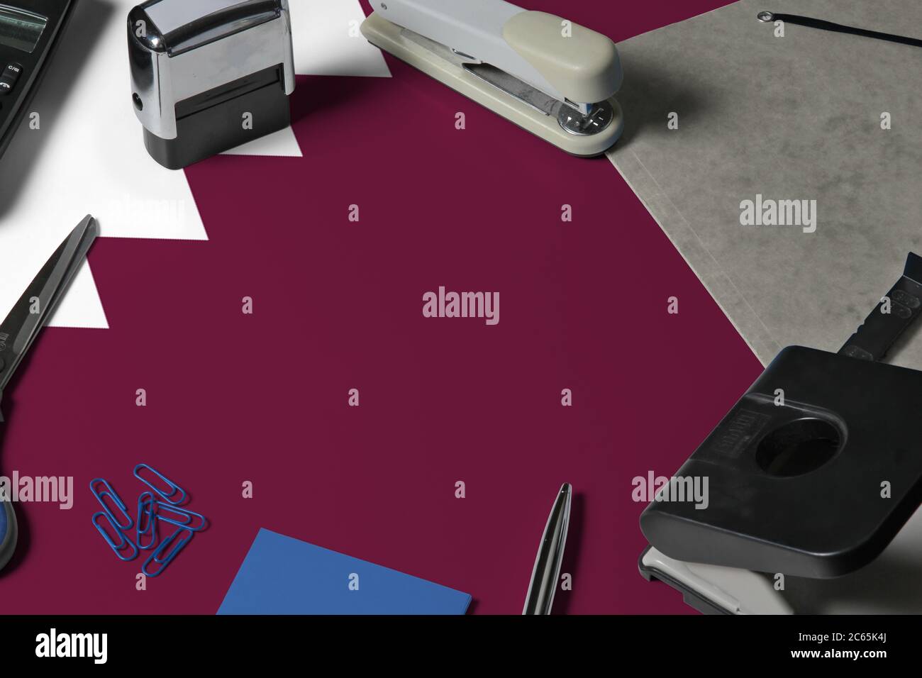 Qatar flag with office clerk workplace background. National stationary ...