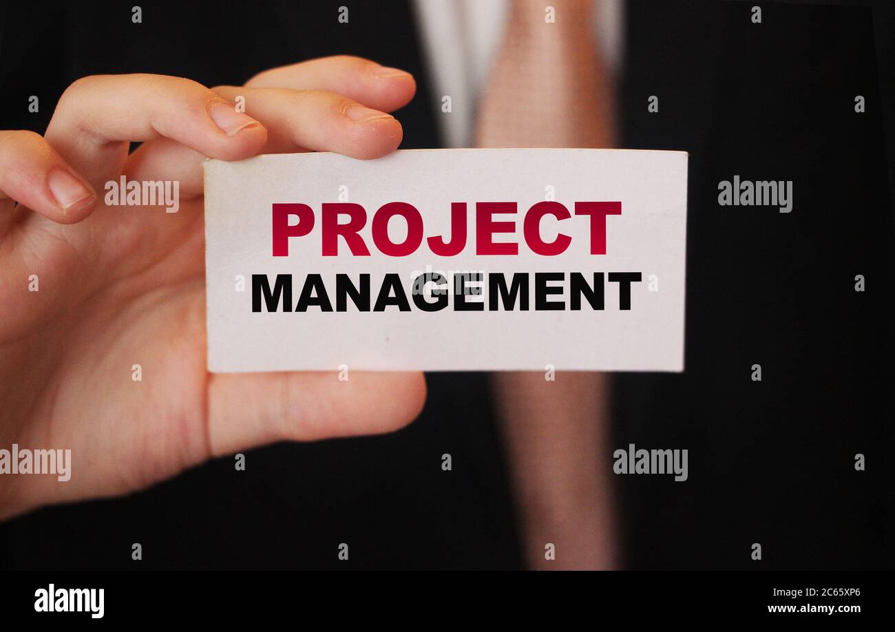PROJECT MANAGEMENT words on card businessman holds. Business strategy human resources HR concept ...