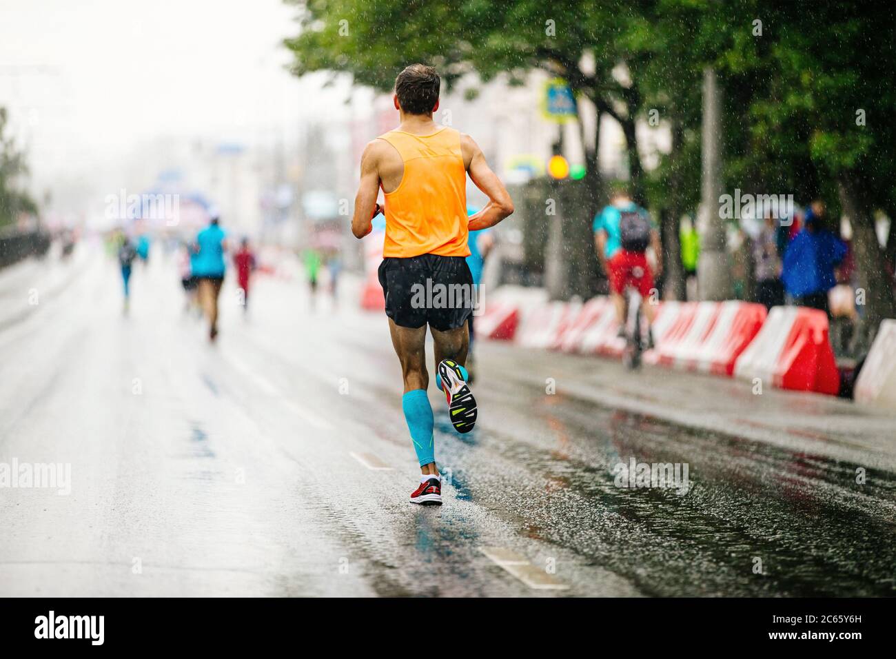 back runner athlete run in rain on road city marathon Stock Photo - Alamy