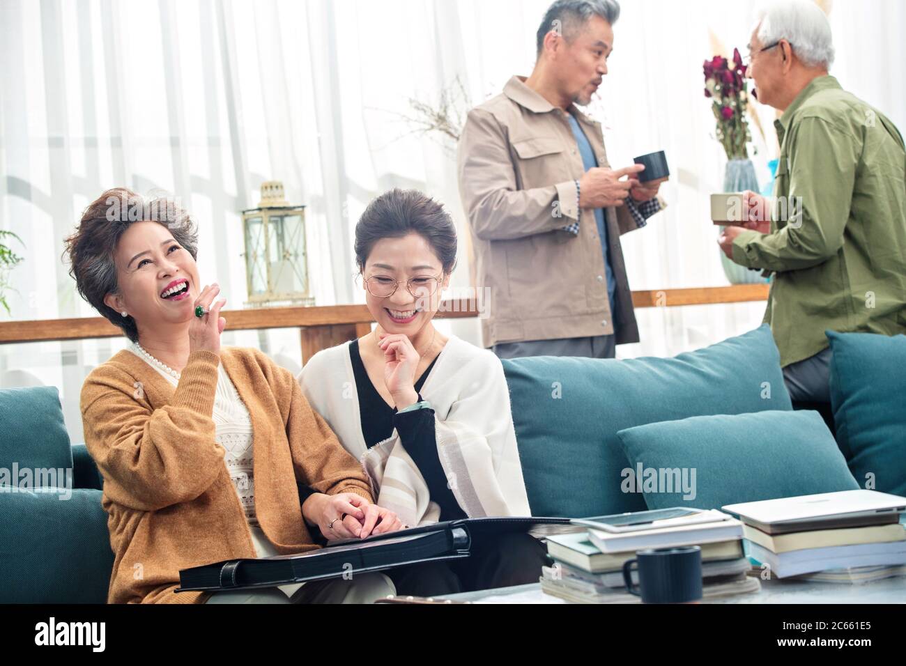 Happy middle-aged and old friends chat photo album Stock Photo - Alamy