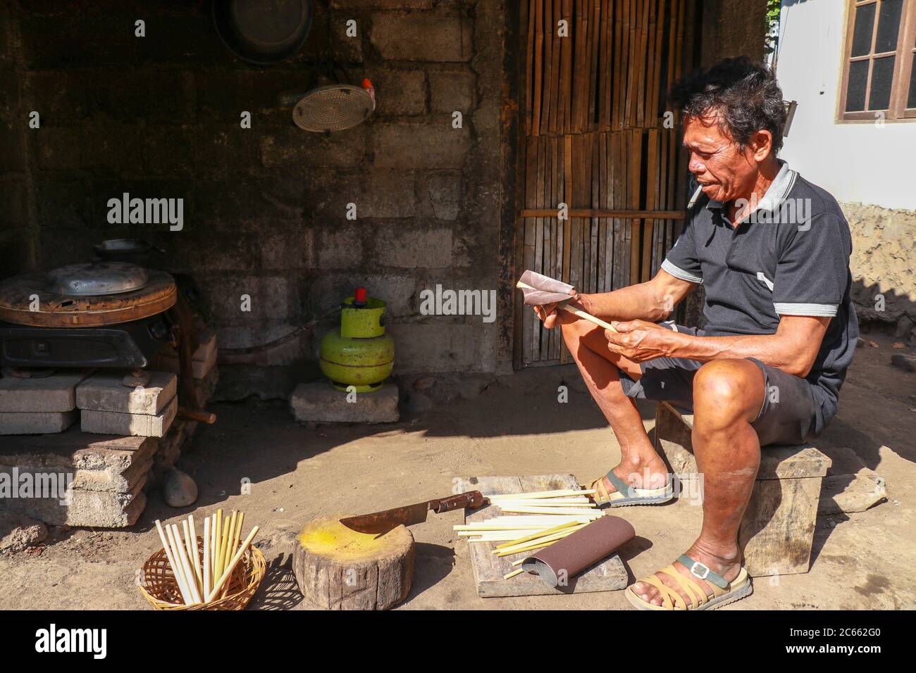 Old man working with bamboo in his workshop to make bamboo straws, Bali ...