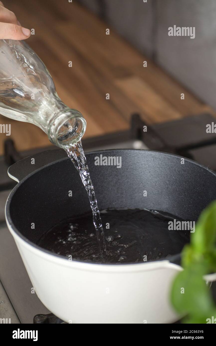 Make your own Ayurveda drink: Pour water into a pot Stock Photo - Alamy
