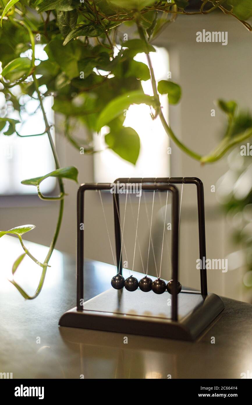 Newton's pendulum on a table still Newton's Cradle Stock Photo - Alamy