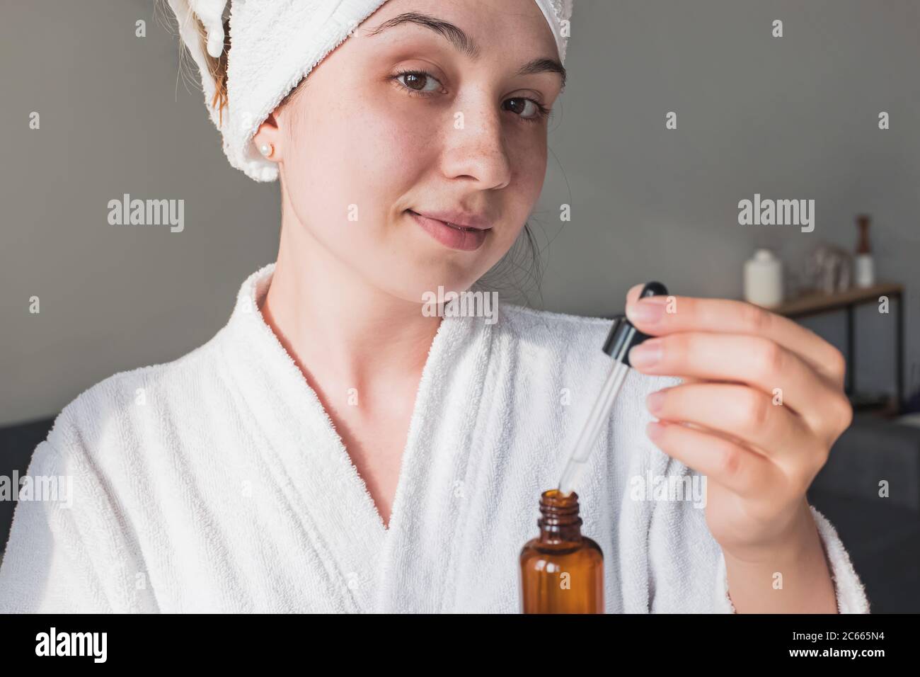 Young woman after shower going to apply beauty serum Stock Photo - Alamy