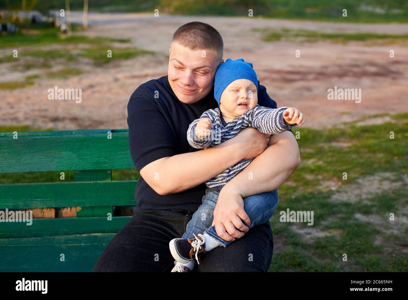 Happy father hugging his little angry son on a bench in the park Stock ...