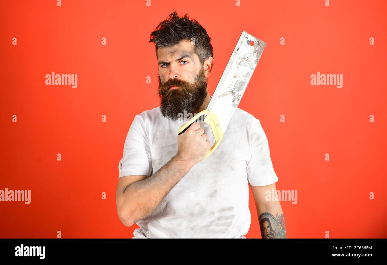 Builder, worker, carpenter, handyman holds saw or hacksaw, red ...