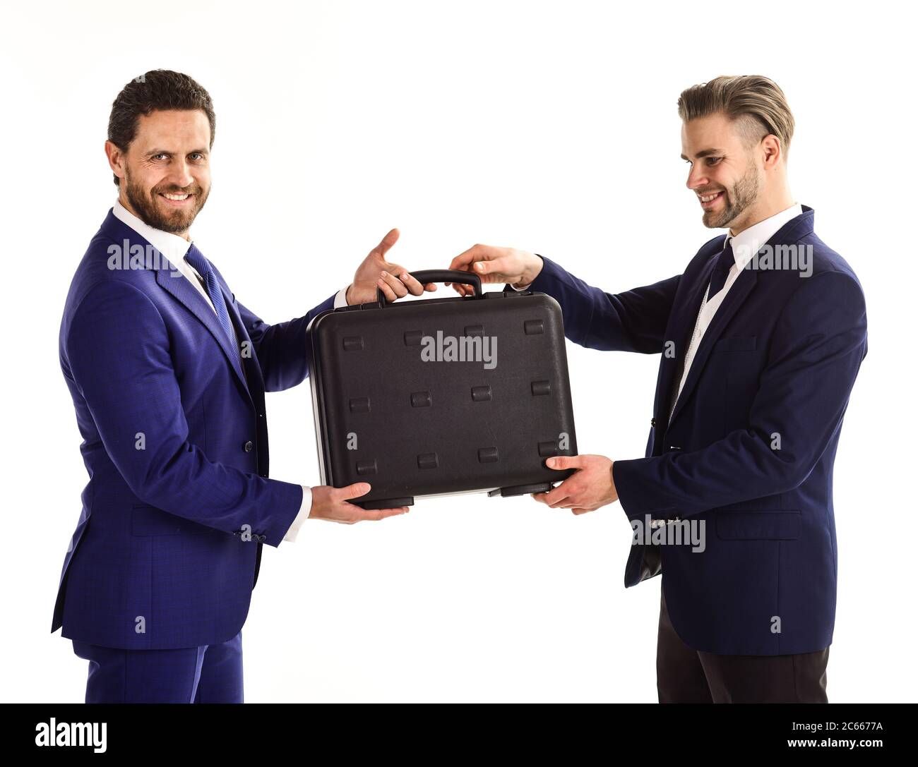Businessmen with happy faces hold black briefcase. Handover of suitcase ...