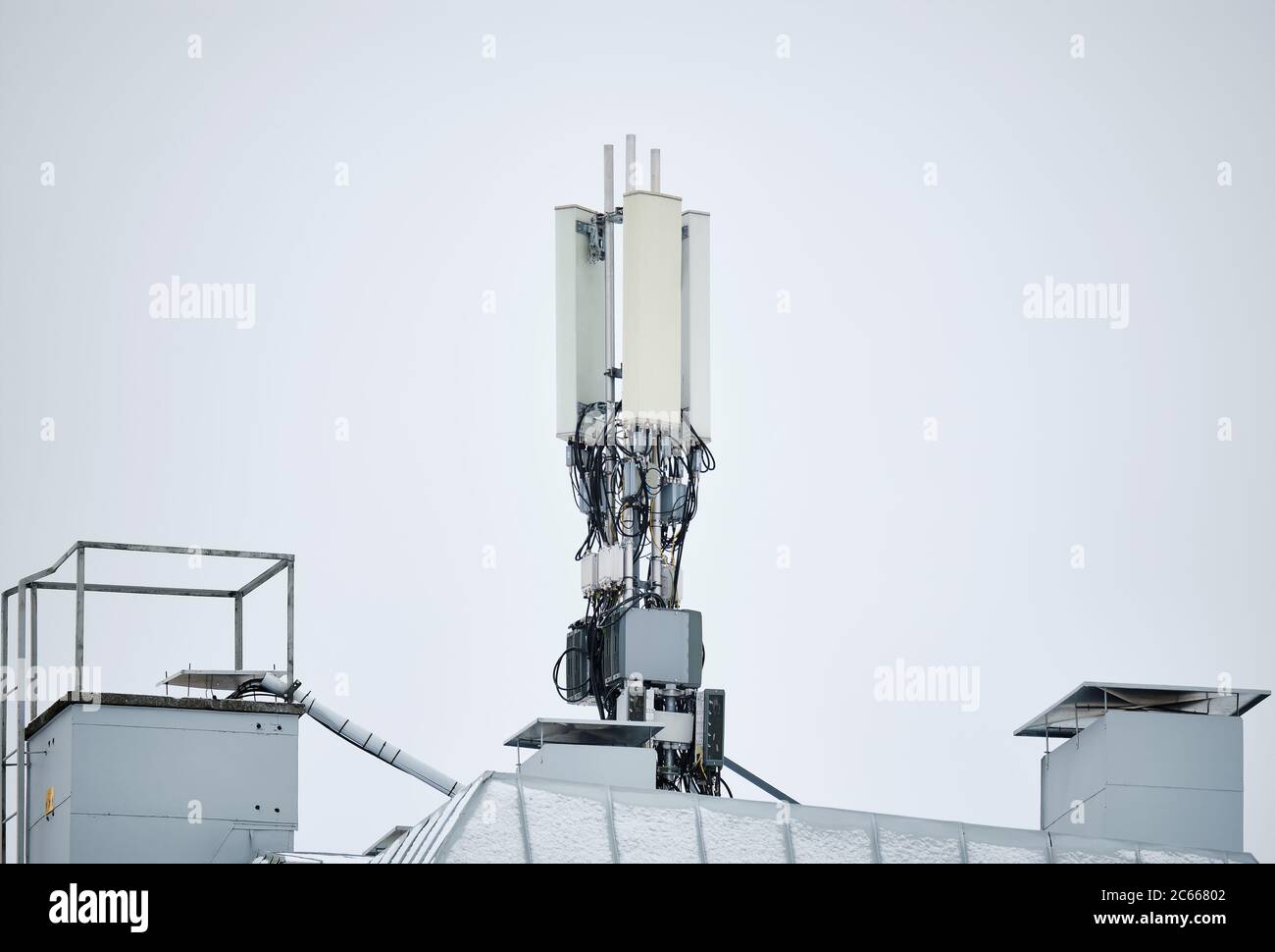 Cellular phone network telecommunication tower on the building roof ...