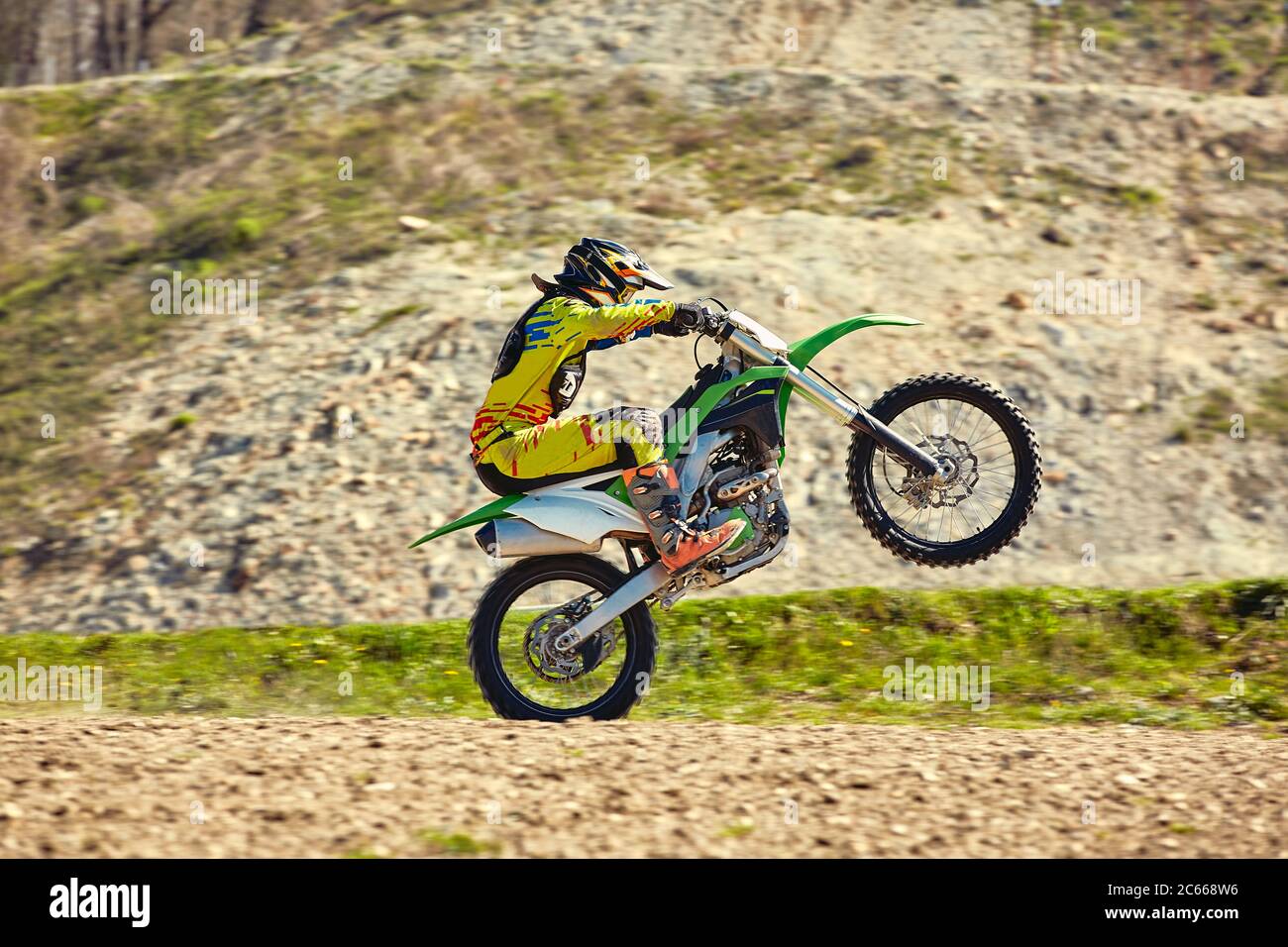 Motocross driver in action accelerating the motorbike takes off and ...