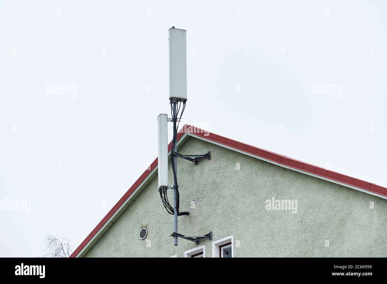 Cellular phone network telecommunication tower on the building roof ...