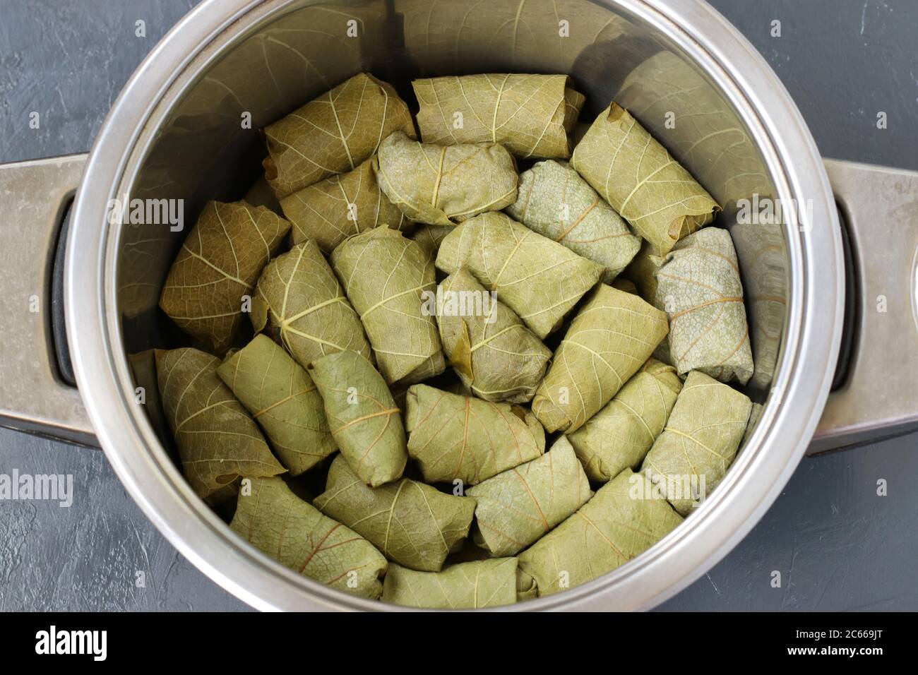 Dolma - stuffed grape leaves with rice and meat stacked in layers in a ...