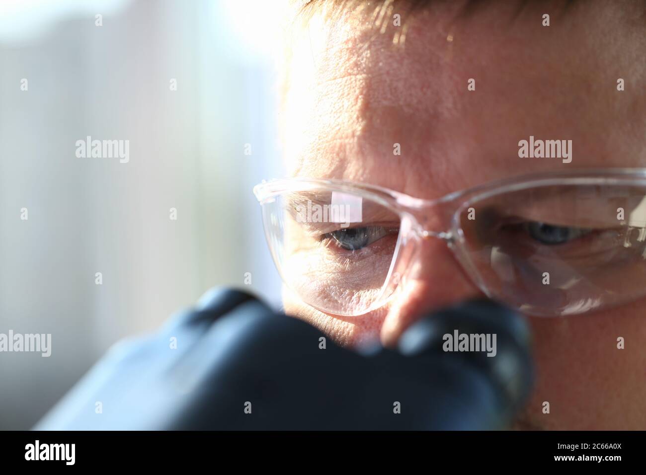 Male scientist looking through binocular in lab Stock Photo - Alamy