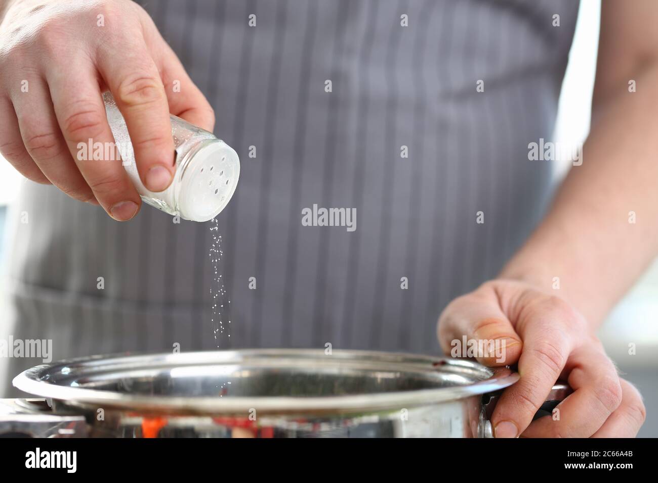 Cook is using spices while cooking dinner Stock Photo - Alamy