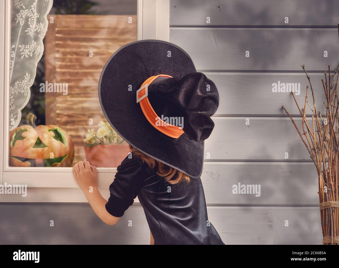 Happy Halloween! Cute cheerful little witch outdoors. Beautiful child ...