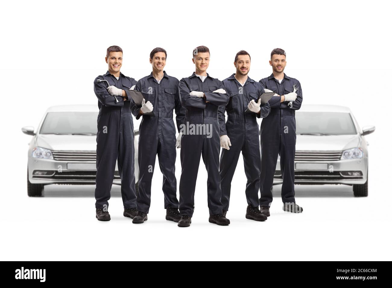 Group of auto mechanic workers posing in front of two cars isolated on ...