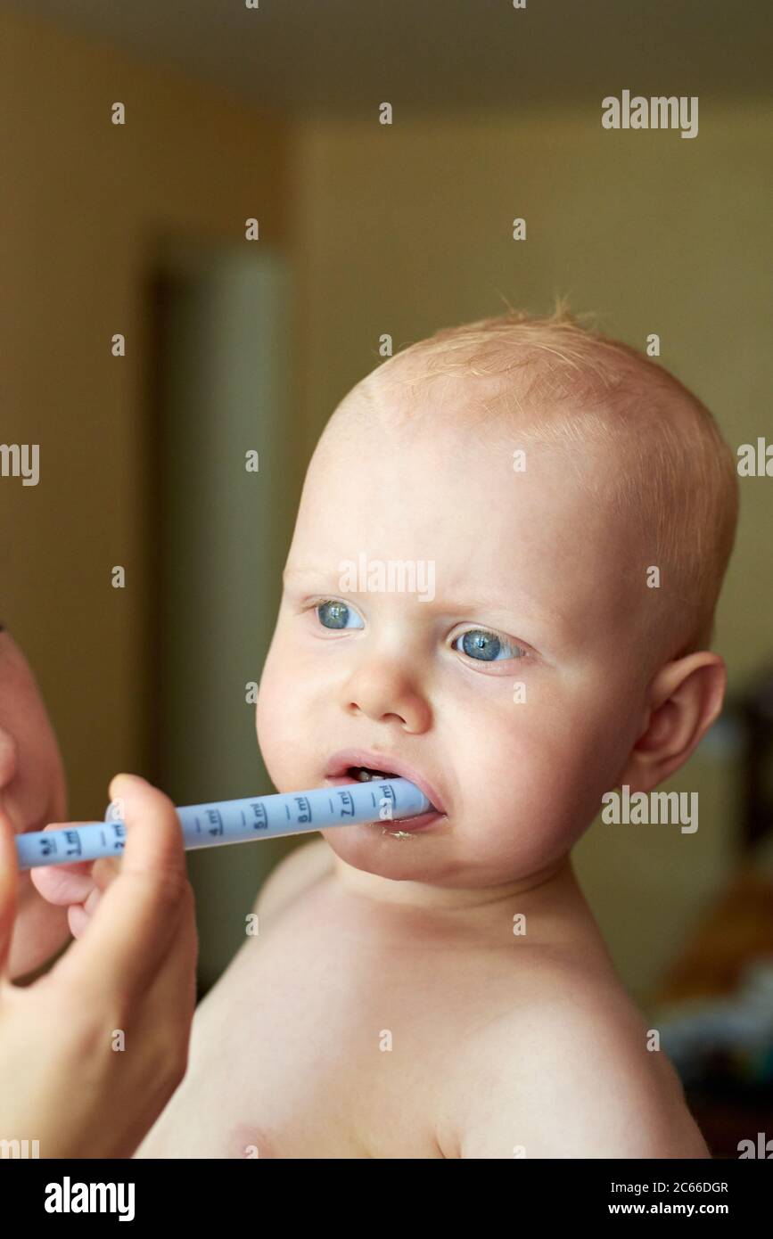 Mom gives her little child medicine through a syringe Stock Photo - Alamy