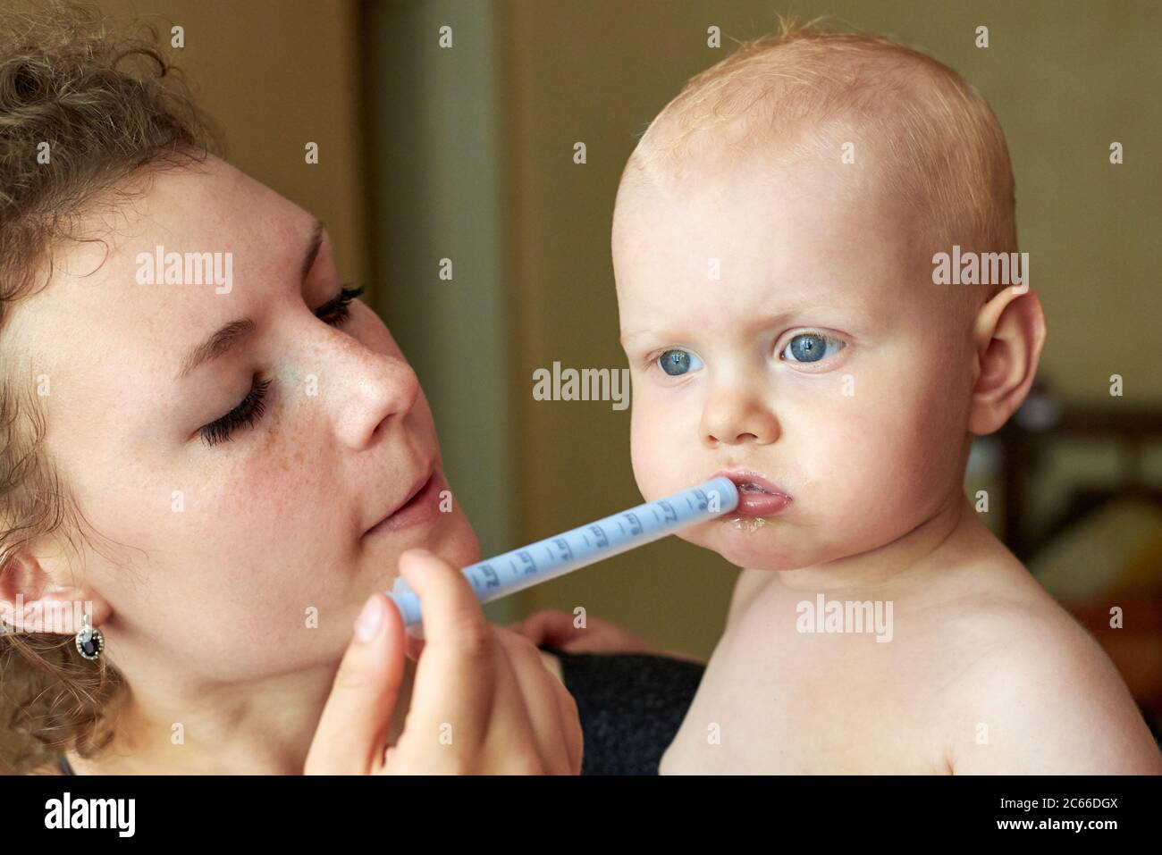 Mom gives her little child medicine through a syringe Stock Photo - Alamy
