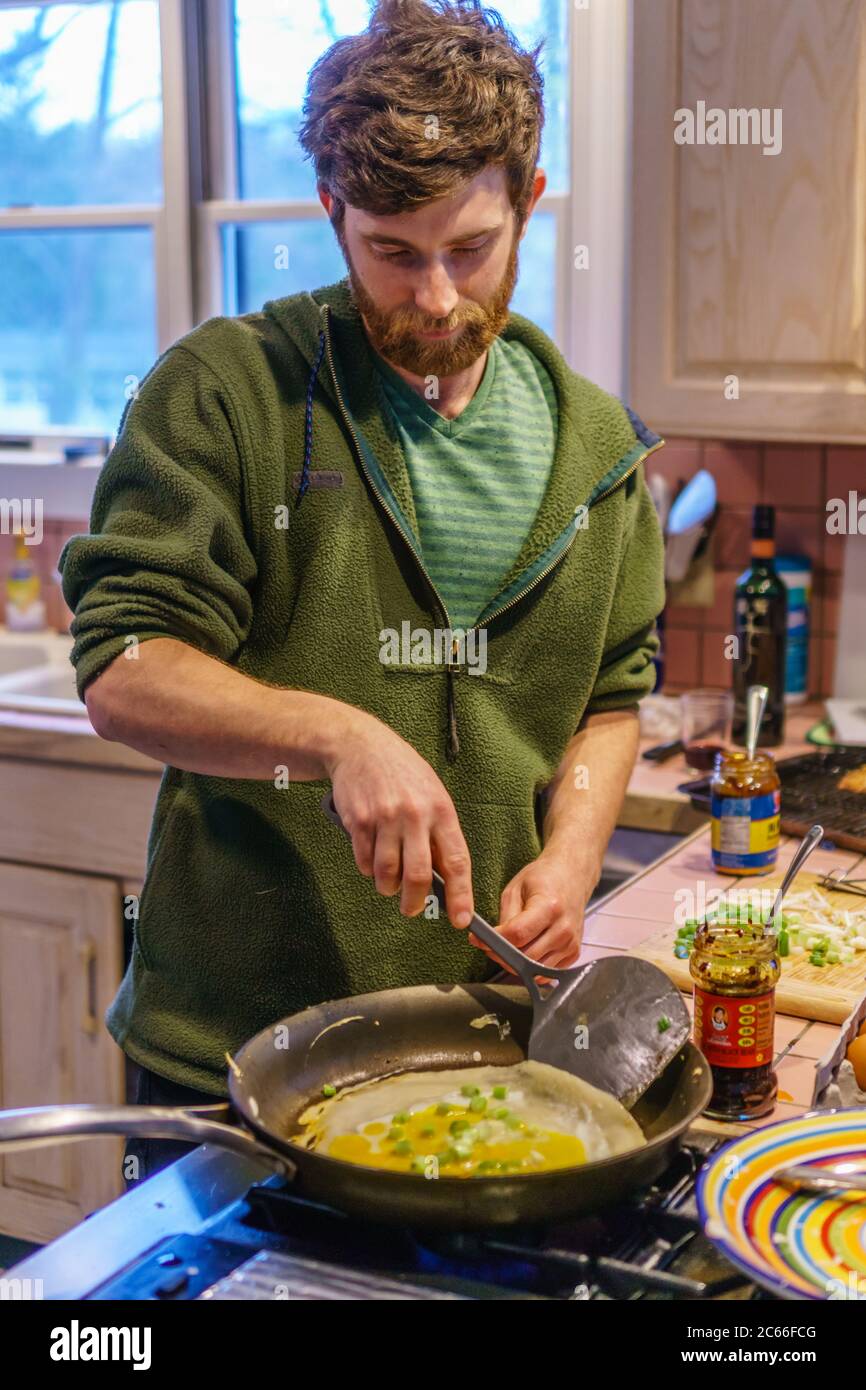 Millennial man cooking at home in kitchen Stock Photo - Alamy