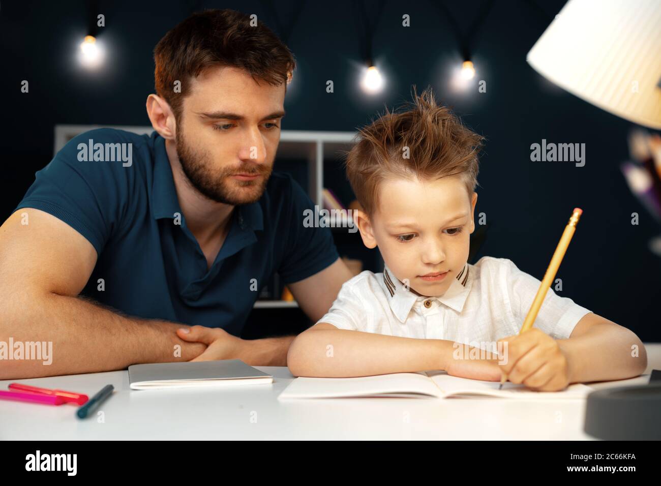 Dad and son doing school homework together Stock Photo - Alamy