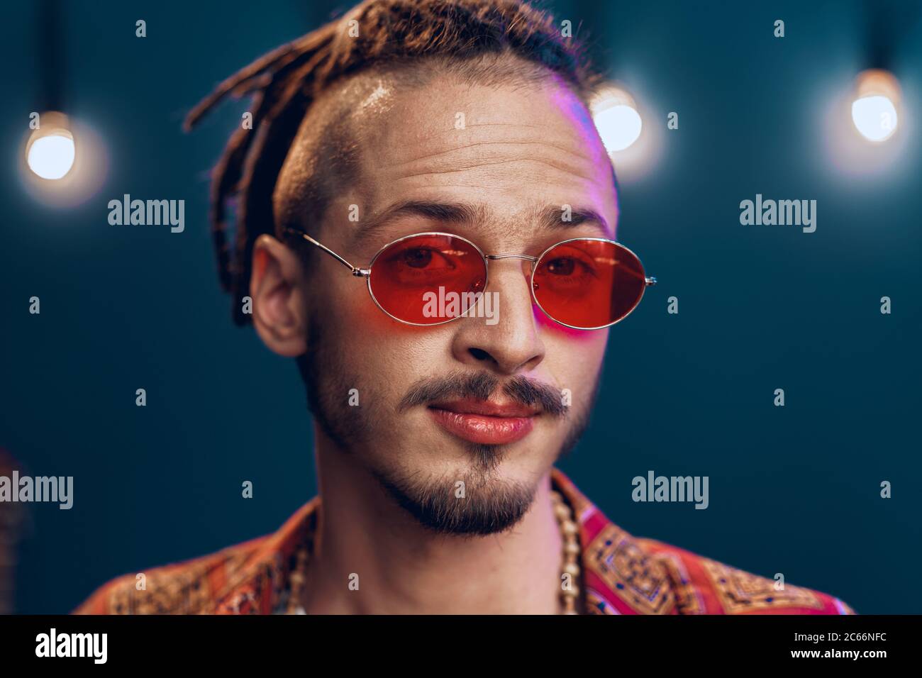 Stylish guy with dreadlocks wearing pink sunglasses Stock Photo - Alamy
