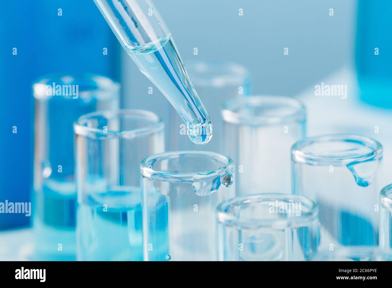 Laboratory glassware with a dropper dripping liquid into a test tube ...