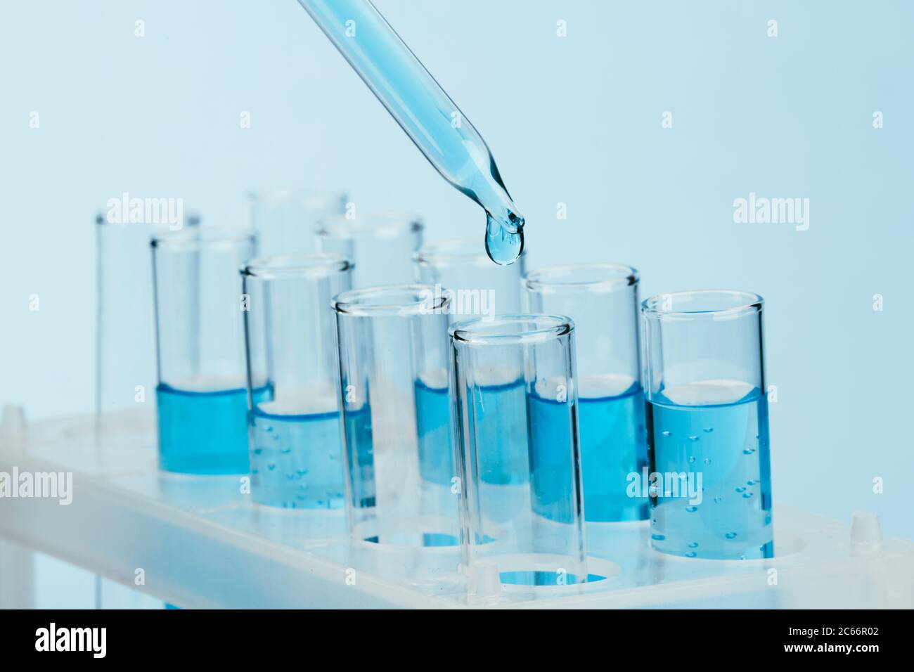 Laboratory glassware with a dropper dripping liquid into a test tube ...