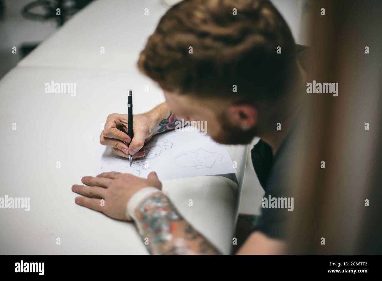 young tattoo artist drawing Stock Photo - Alamy