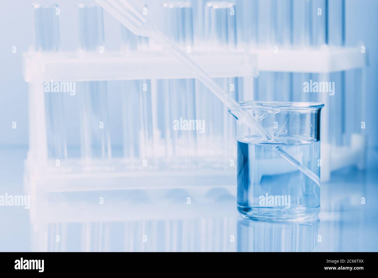 Laboratory glassware with a dropper dripping liquid into a test tube ...