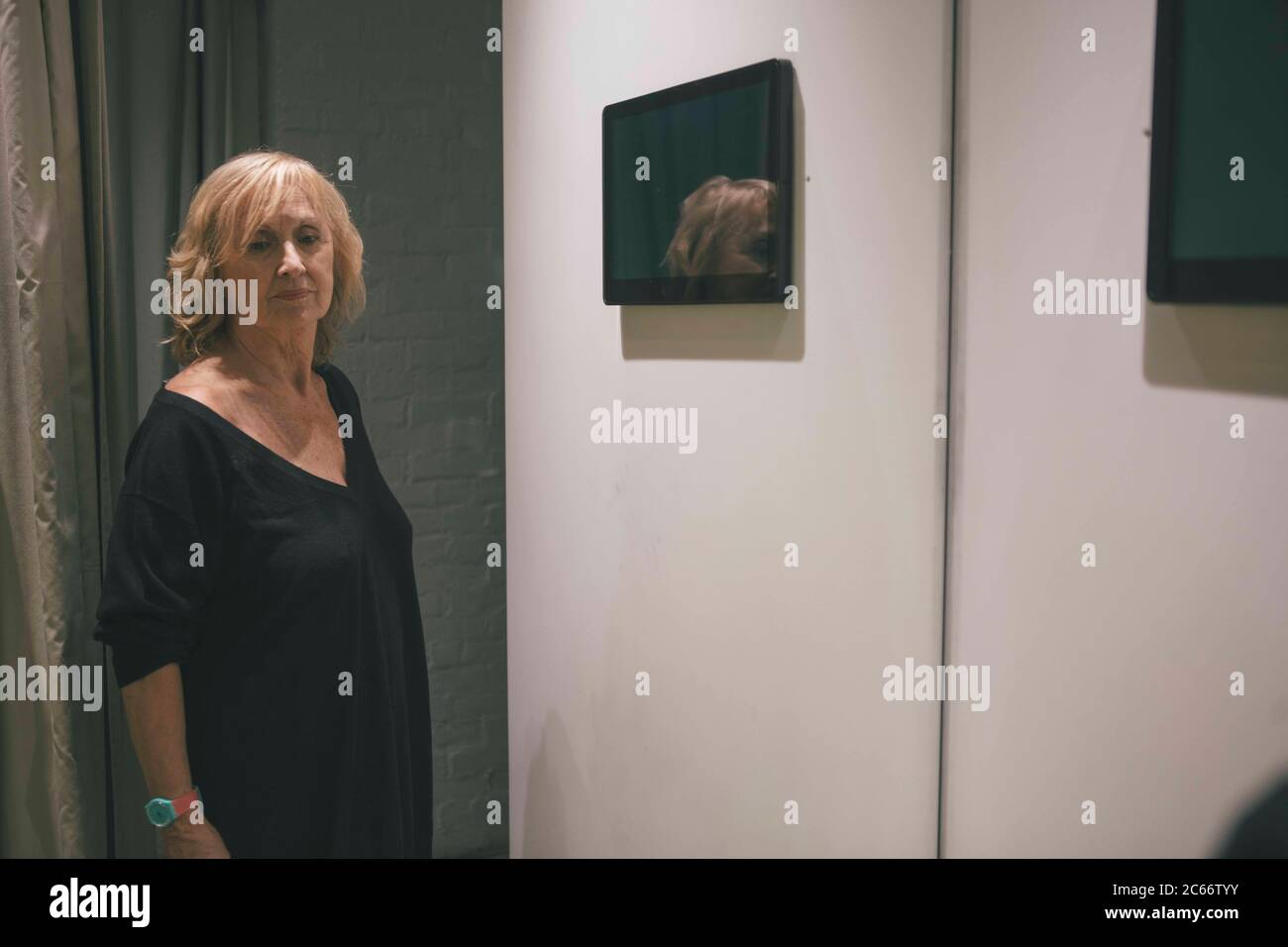 a mature woman fitting clothes on a fitting room, not happy Stock Photo ...