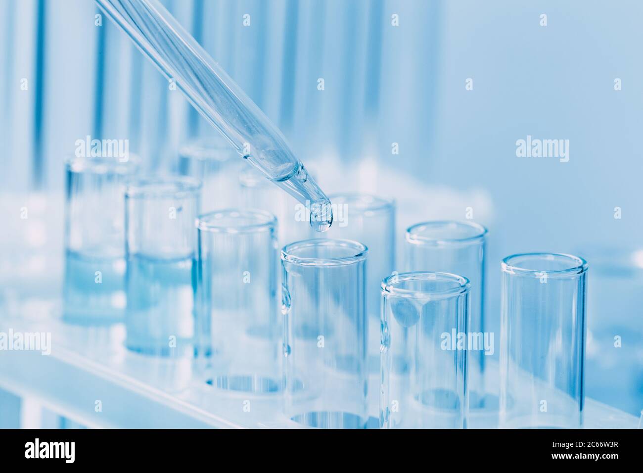 Laboratory glassware with a dropper dripping liquid into a test tube ...