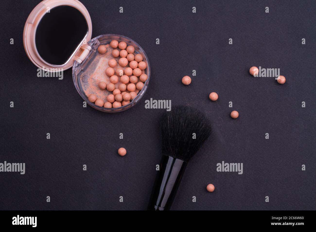 Face powder makeup balls and black brush on black background Stock ...