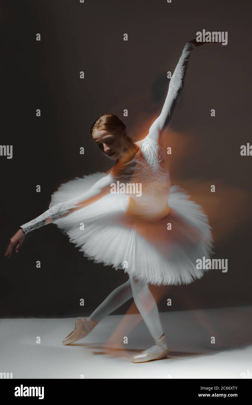 ballerina in white ballet dress dancing in dark class, motion blur ...