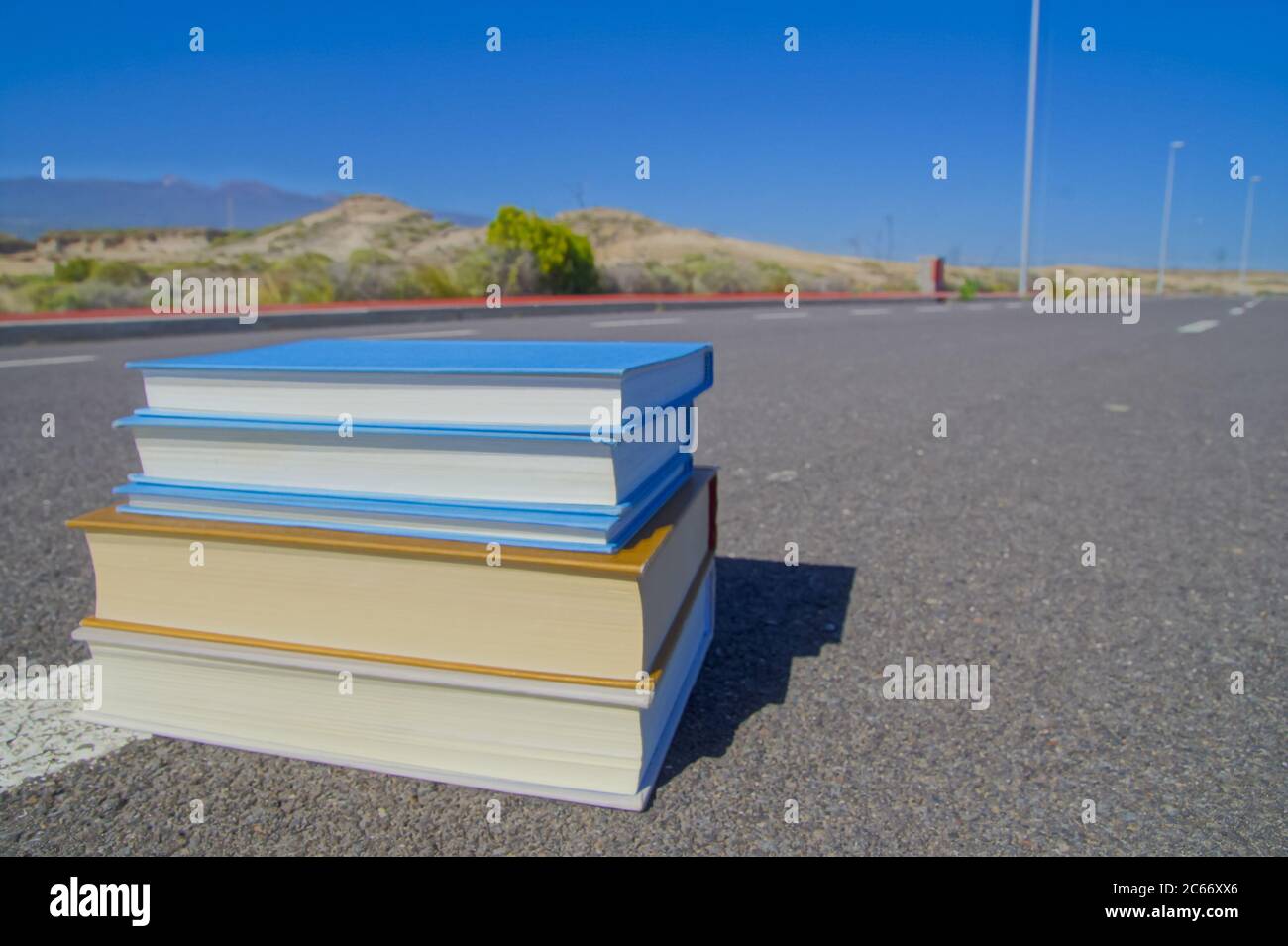 On the Road Literature Concept Books over Asphalt Stock Photo - Alamy