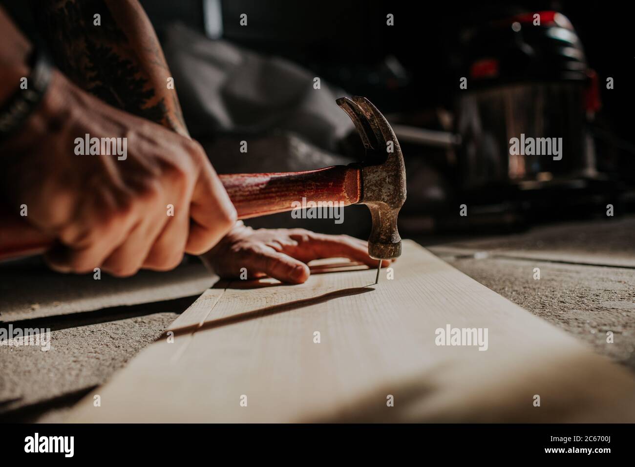 Man hammering nail into board Stock Photo - Alamy