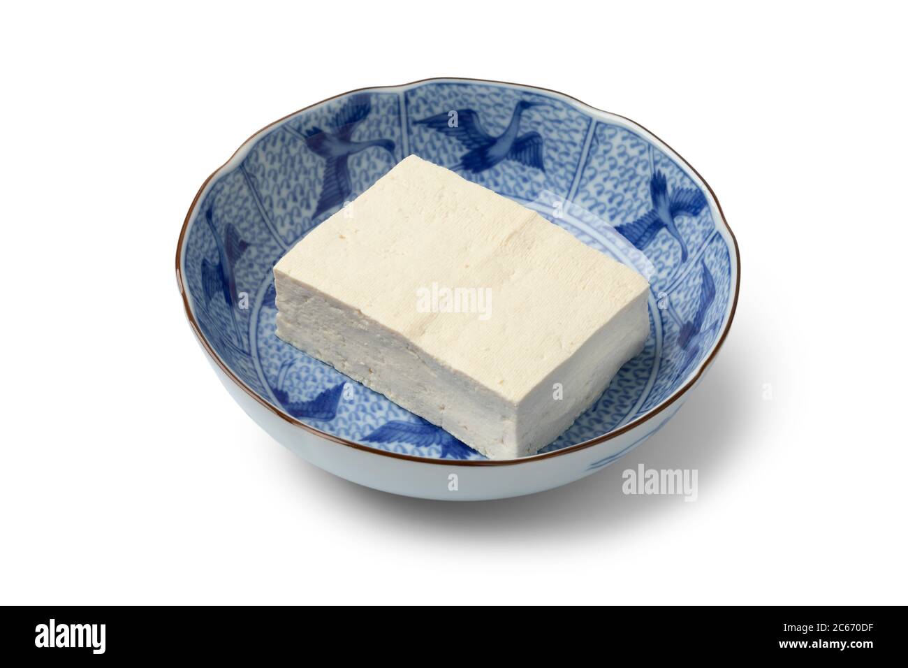 Piece of fresh white regular tofu in a Japanese bowl close up isolated ...