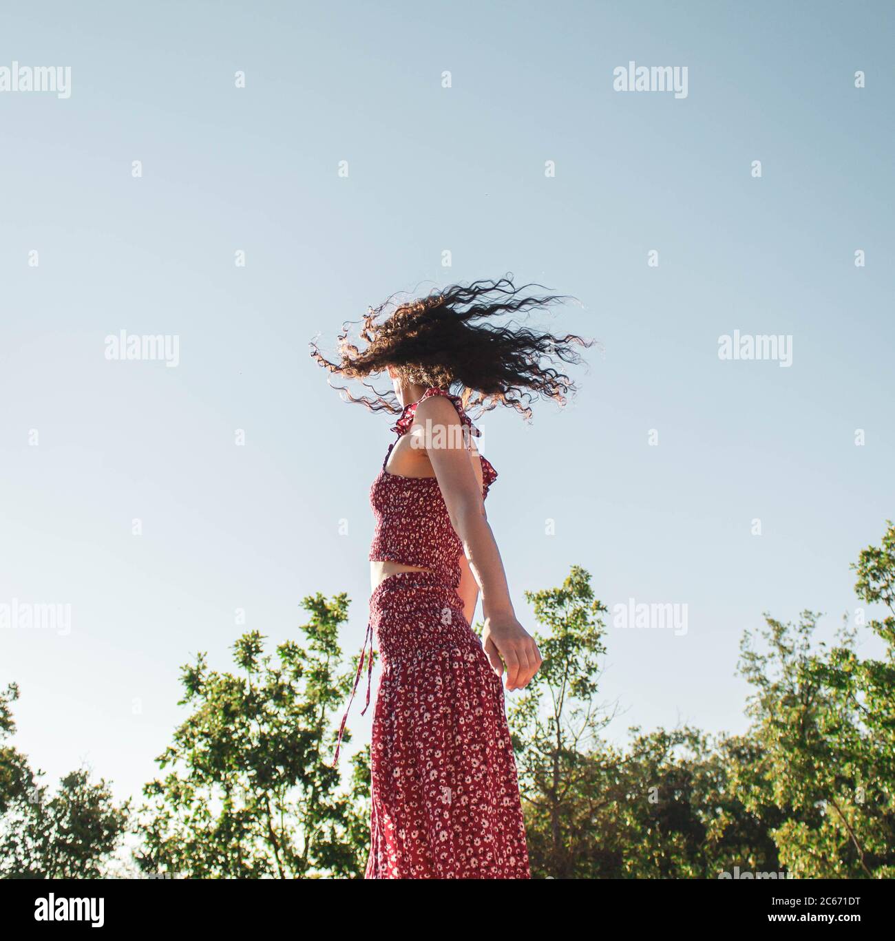 brunette girl moving hair with long summer dress against blue sky Stock ...