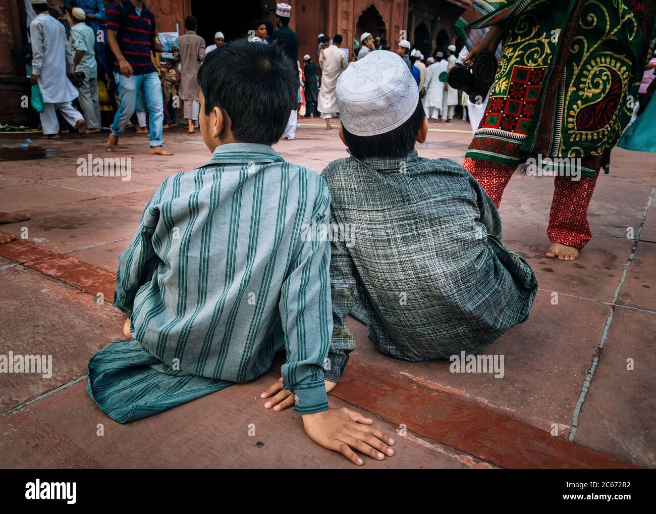 Two kids observing the crowd at Jama Masjid, Delhi, India Stock Photo ...