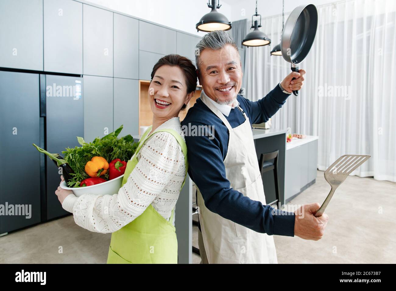Middle-aged couples in the kitchen cooking Stock Photo - Alamy