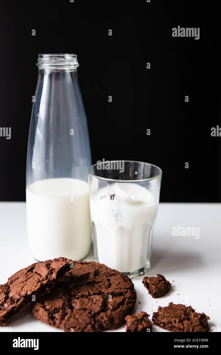 pouring milk in glass with chocolate cookies Stock Photo - Alamy