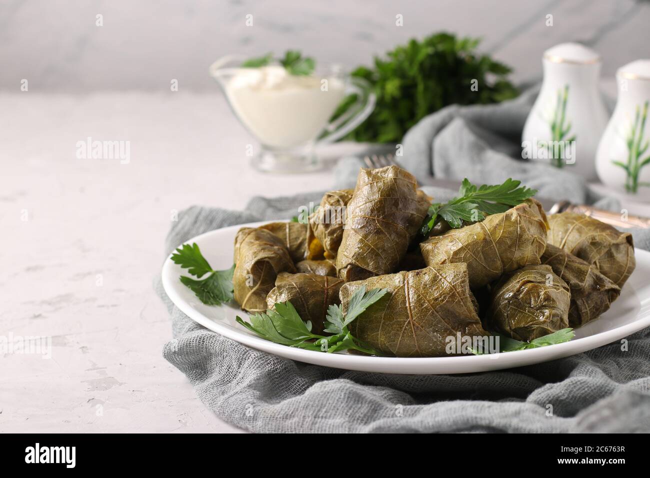 Dolma - stuffed grape leaves with rice and meat on a white plate on ...